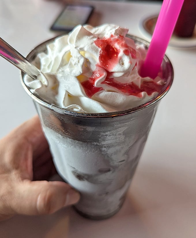 This isn't just a milkshake—it's dessert with a straw. Topped with whipped cream and strawberry sauce, it's worth every calorie and brain freeze.