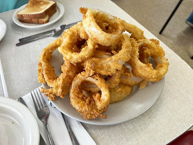 These onion rings aren't just side dishes—they're golden halos of happiness that make you wonder why vegetables ever bothered growing any other way.