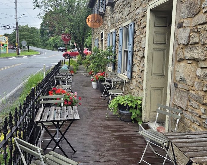Al fresco dining at its most charming – where weathered wood, potted geraniums, and the promise of exceptional food create an irresistible sidewalk sanctuary.