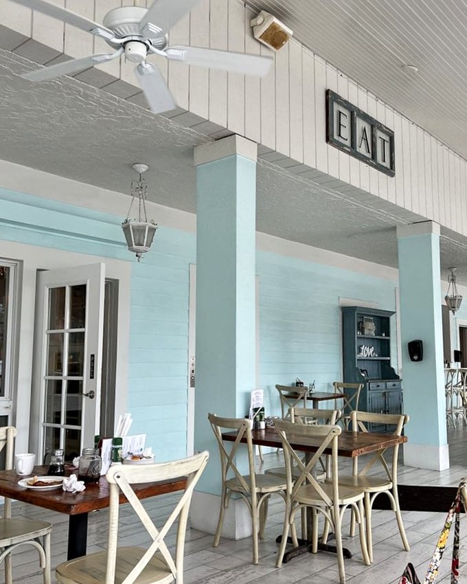 The outdoor dining area whispers "stay awhile" with its coastal blue columns and simple "EAT" sign—as if we needed convincing.