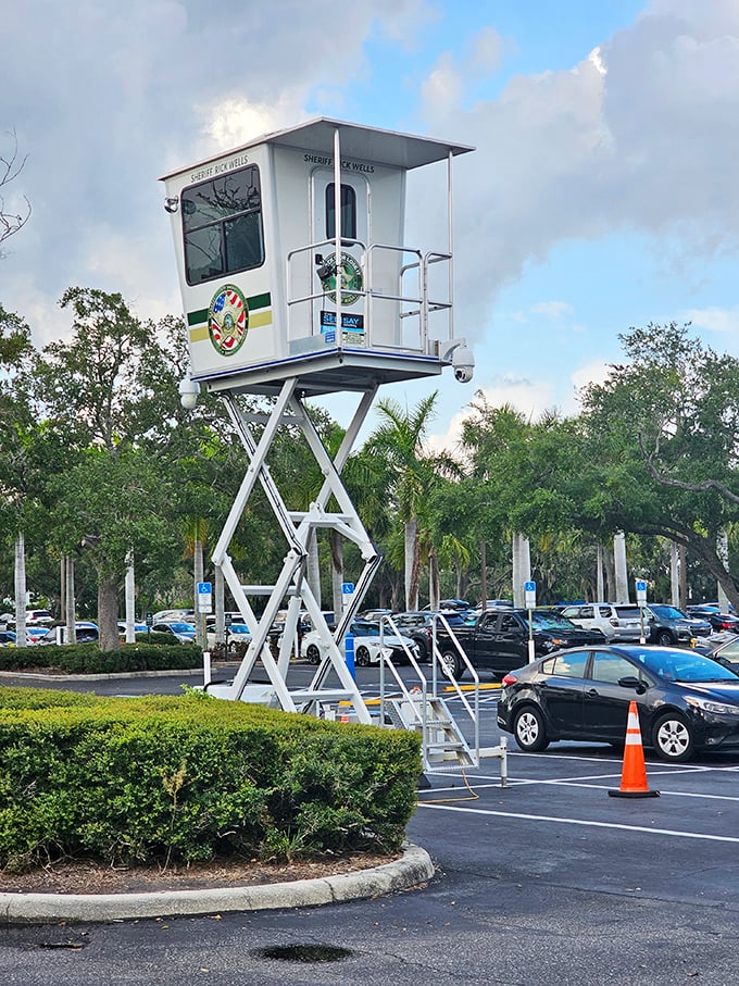 Even the security tower has resort vibes – watching over a sea of parked cars whose trunks will soon be filled with shopping victories.