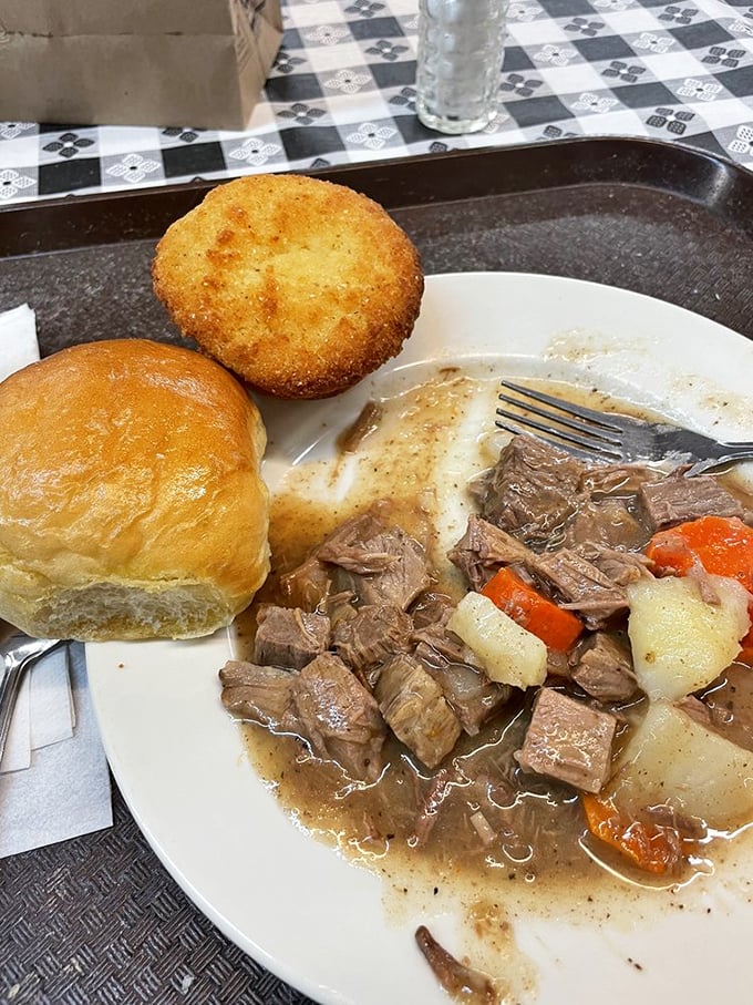 Pot roast that doesn't just fall apart—it surrenders completely, alongside a cornbread muffin standing guard.