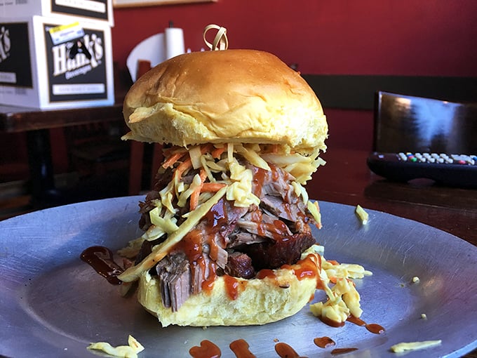 Not your average sandwich—this pulled pork masterpiece, crowned with slaw and sauce, demands both hands and your undivided attention.