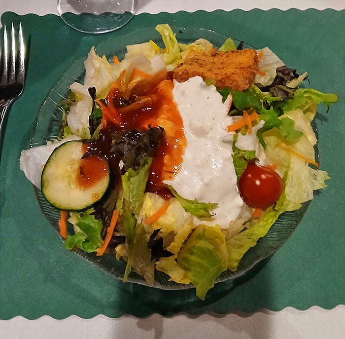 Garden-fresh salad with house dressing – the opening act that deserves its own standing ovation. Even vegetables dress up for dinner here.