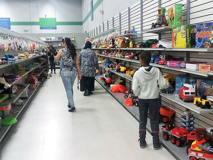 Fellow treasure hunters navigate the aisles with the focused determination of seasoned bargain archaeologists.