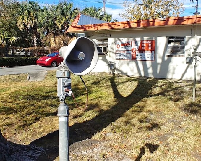 That vintage speaker system isn't retro-chic design—it's the original article, still faithfully connecting hungry customers to burger salvation.
