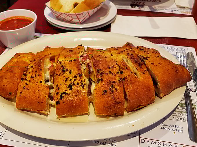 The stromboli arrives like an edible treasure chest—each slice revealing a perfect harmony of meats, cheese, and dough that puts ordinary sandwiches to shame.