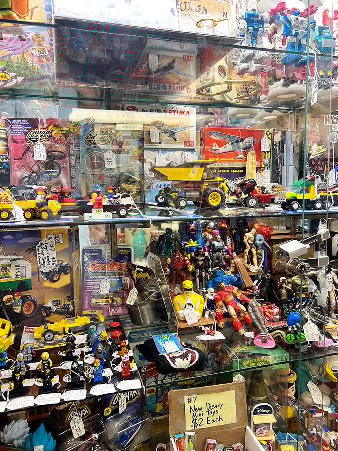 Childhood nostalgia behind glass—where action figures from different decades stand frozen in time, waiting for collectors to rescue them from obscurity.