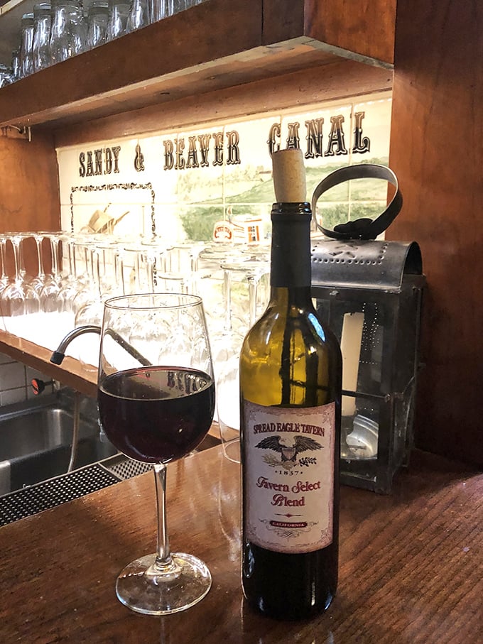 The tavern's house wine sits proudly against a backdrop celebrating Ohio's canal history—proof that good taste flows through every aspect of this establishment.