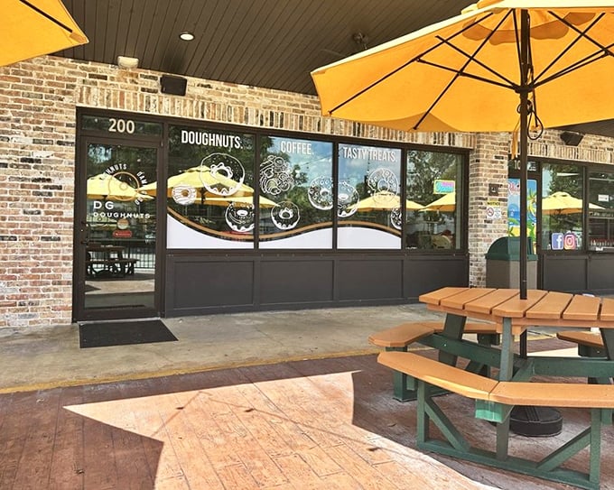 Brick walls and golden umbrellas create an upscale atmosphere where gourmet doughnuts meet café culture perfectly.