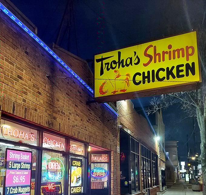 Troha's bright yellow sign cuts through the night – a neon promise of crispy, golden seafood treasures within.