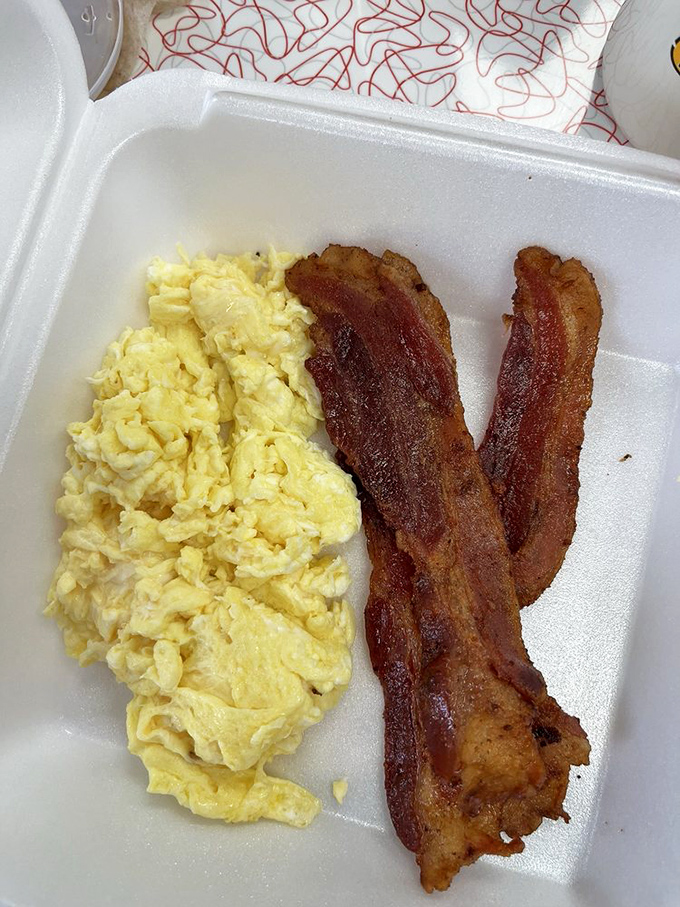 Scrambled eggs and crispy bacon in their natural habitat - a simple styrofoam container.