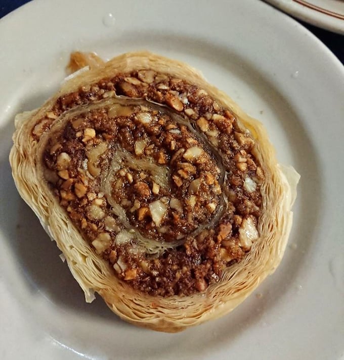 Baklava done right – layers of phyllo as delicate as butterfly wings, cradling honey-soaked nuts in what might be the world's most perfect dessert architecture.