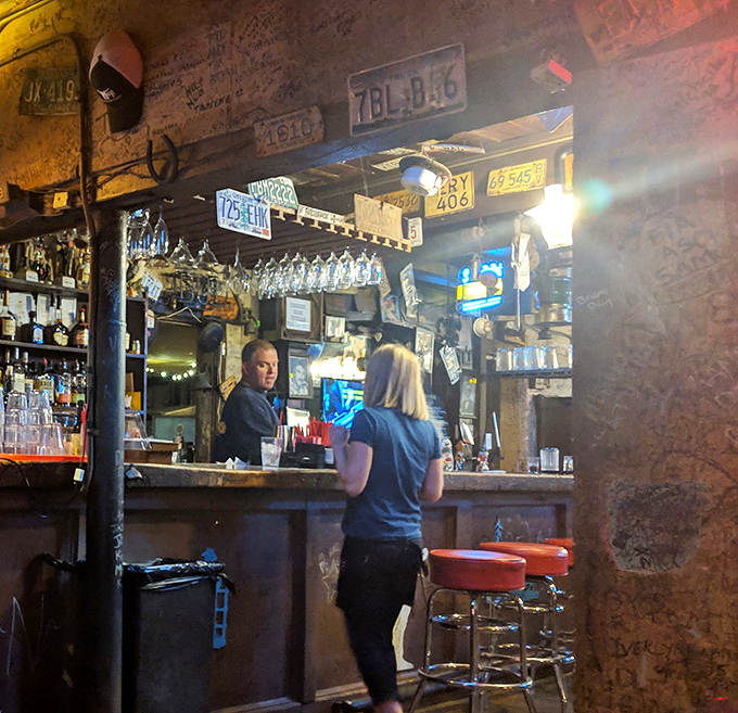 The bar isn't just serving drinks—it's serving history. Every license plate and wall scribble tells a story that gets better after your second bourbon.