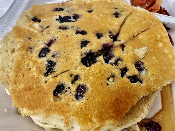 Blueberry pancakes that look like they're auditioning for a breakfast cereal commercial – golden, fluffy, and studded with berries that burst with every bite.