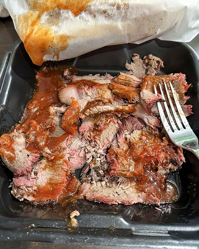 Brisket with that telltale pink smoke ring—nature's way of saying "this was done right." The fork is merely a suggestion.