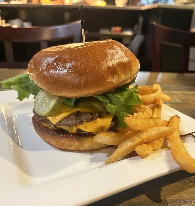 The burger that launched a thousand napkins – juicy, cheese-draped perfection on a glossy bun with fries that demand equal attention.
