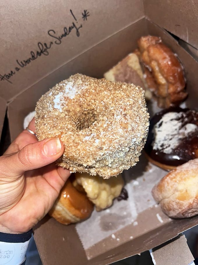 This crunch donut isn't just holding its hand up—it's waving you over to experience its golden-fried perfection.