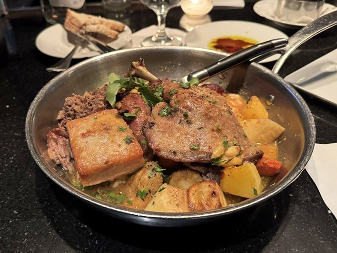 The cassoulet arrives like a rustic poem in a skillet—duck, pork, and beans having what appears to be the world's most delicious reunion.