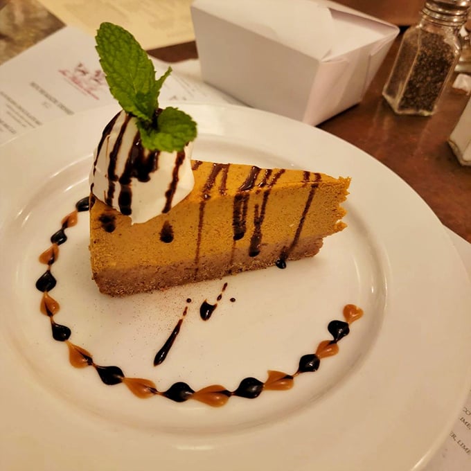 A slice of cheesecake that demands a moment of silence. The artistic sauce drizzles aren't just for show—they're flavor pathways to dessert nirvana.
