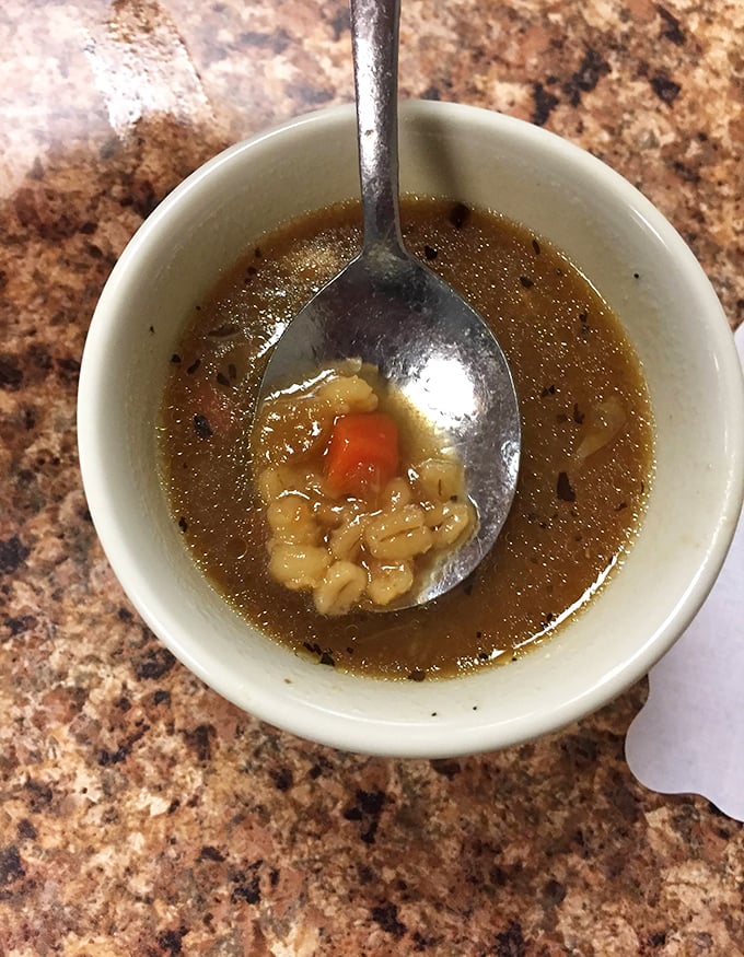 Homemade soup that looks like it simmered while dinosaurs roamed the earth—deep, rich broth that could cure anything from colds to existential crises.