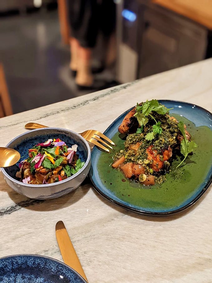 Two plates in perfect harmony—like a culinary duet that hits all the right notes. Bright herbs and rich sauces create a symphony of Haitian flavors.