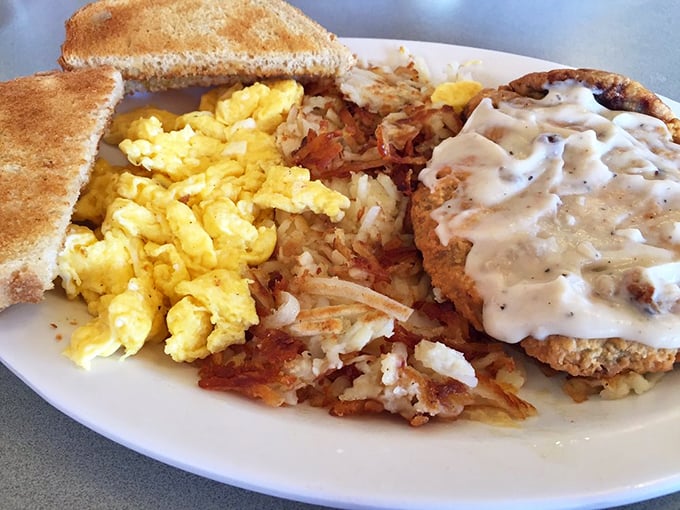 Chicken fried steak wearing its gravy like a warm blanket on a cold morning – pure comfort.
