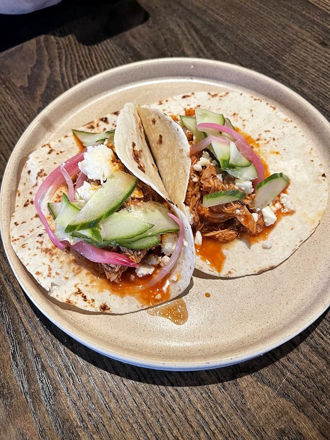 These aren't just tacos – they're carefully constructed flavor vessels where every cucumber slice and red onion has been placed with surgical precision.