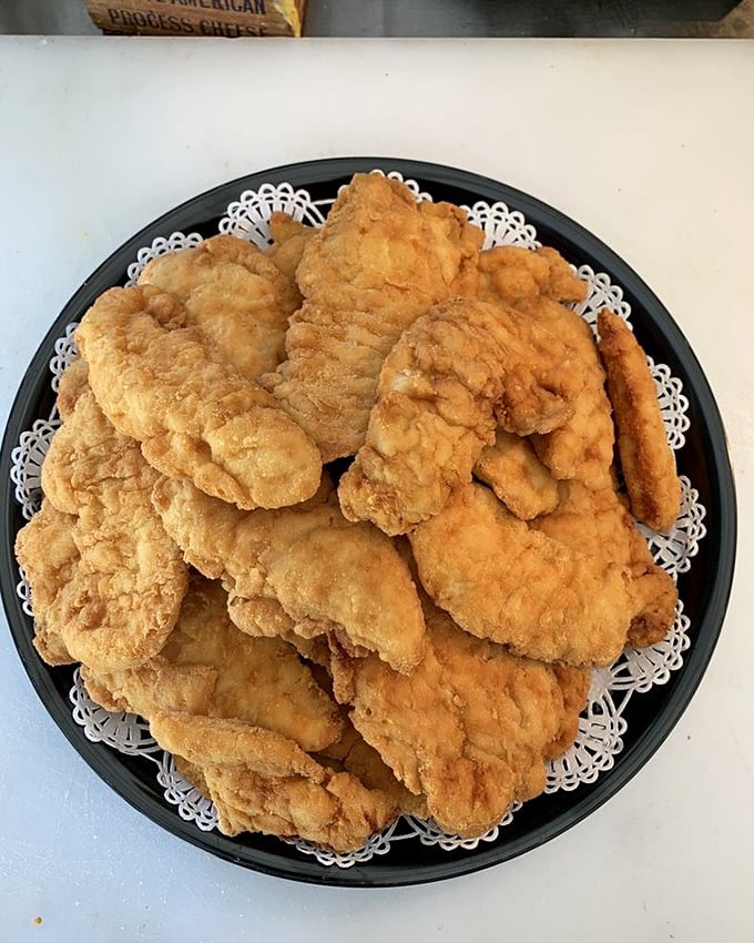Chicken tenders that could make a vegetarian weep. Golden-brown perfection arranged on a doily—because even comfort food deserves a proper presentation.