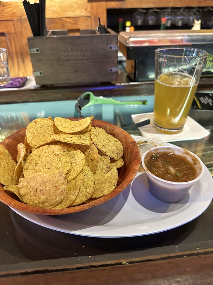 Simple pleasures done right—golden chips, house-made salsa, and a cold beer. Sometimes happiness really is that straightforward.