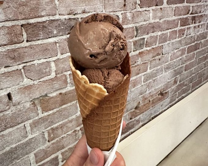 This chocolate gelato cone isn't just dessert—it's therapy in edible form, with the exposed brick providing the perfect Instagram backdrop.