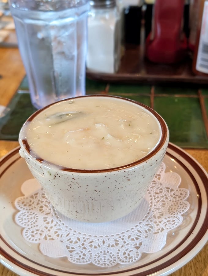 A cup of clam chowder served on a doily—because even comfort food deserves a touch of elegance on the Oregon coast.