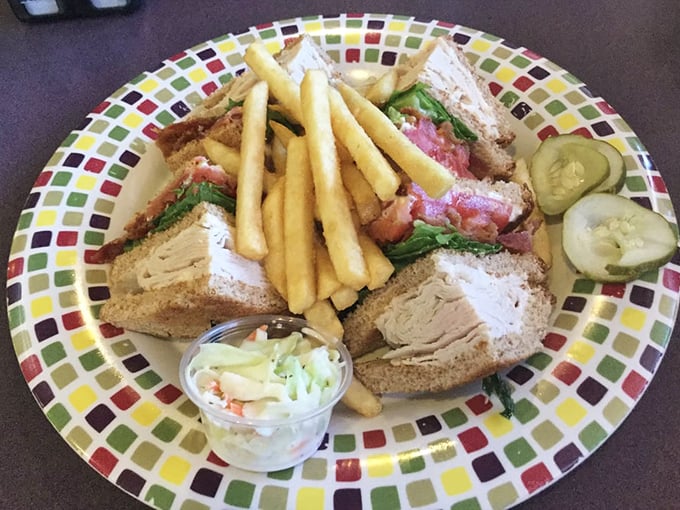 The club sandwich—architecture you can eat! Layers of goodness stacked between toast with crispy fries standing guard.
