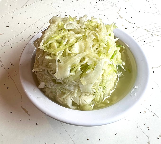 The vinegar-based coleslaw cuts through the richness of fried chicken like a refreshing palate cleanser between bites of heaven.