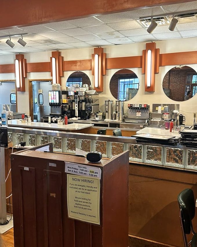Art deco lighting fixtures and circular windows give the counter area a timeless quality—Edward Hopper would've loved to paint this scene.