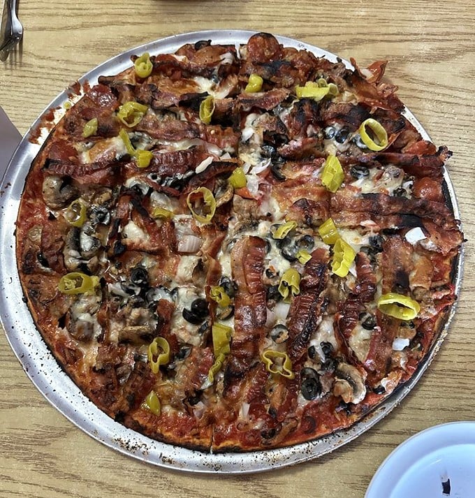 This isn't just pizza—it's a circular manifesto of excess, where bacon, mushrooms, and banana peppers create a symphony of savory satisfaction.