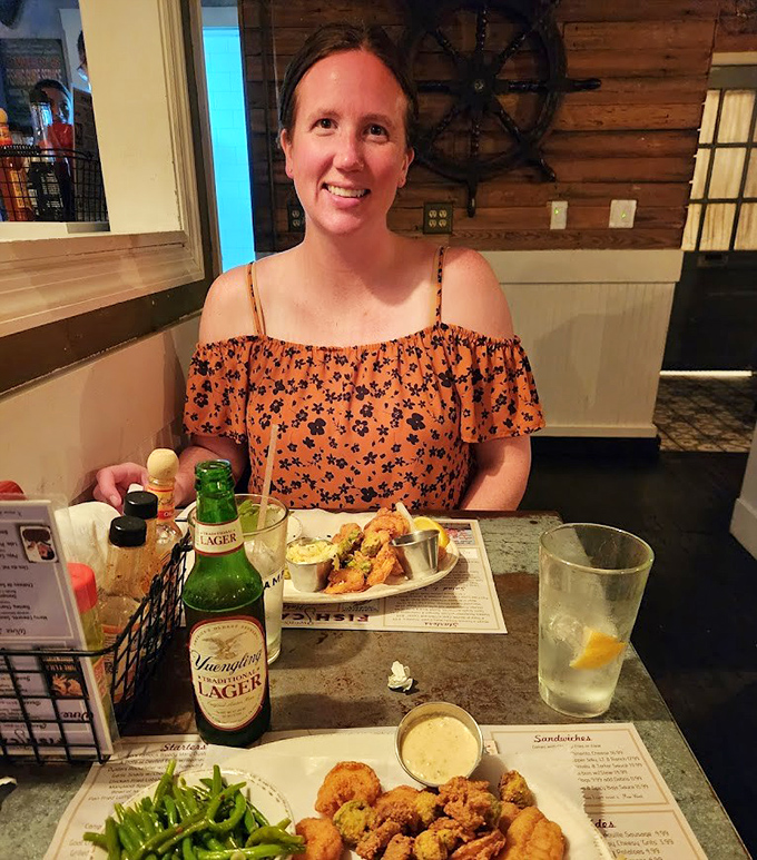 Happy diners surrounded by fried treasures from the sea – proving that sometimes the best vacation souvenirs are the ones you digest.