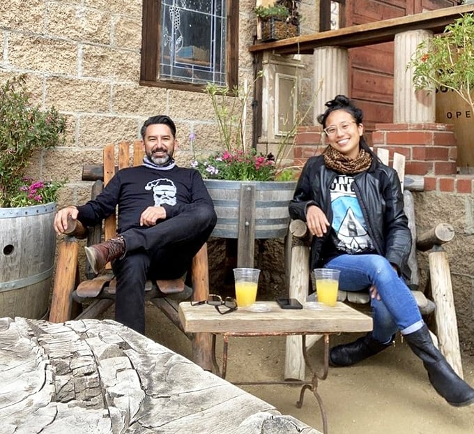 The outdoor seating area invites relaxation with rustic chairs and sunshine-filled drinks—a perfect pause in a busy world.