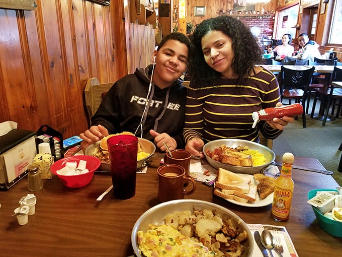 The universal language of breakfast joy—shared across a table laden with skillets of morning perfection. Some traditions are worth preserving.