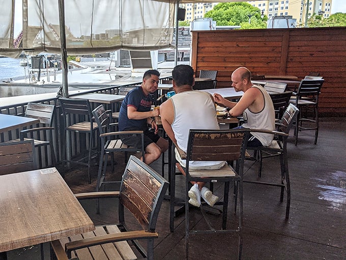 The outdoor deck offers front-row seats to Miami River's aquatic parade—where your dining companions include passing boats and occasional manatees.