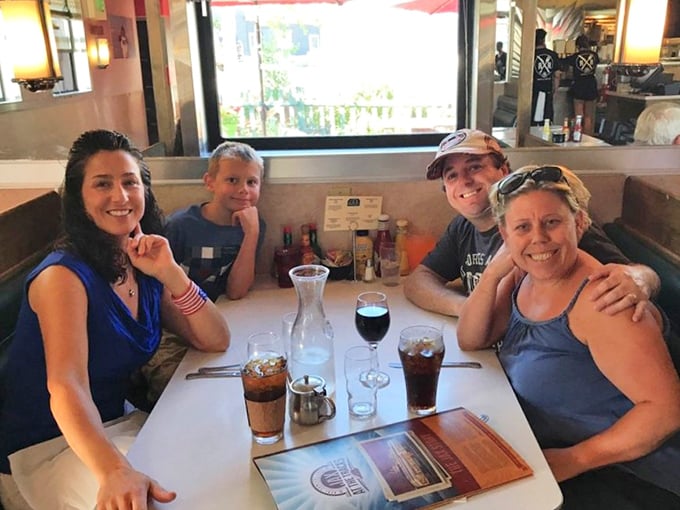 Happy diners gathered around beverages and conversation – the universal language of a great meal shared with people you love.