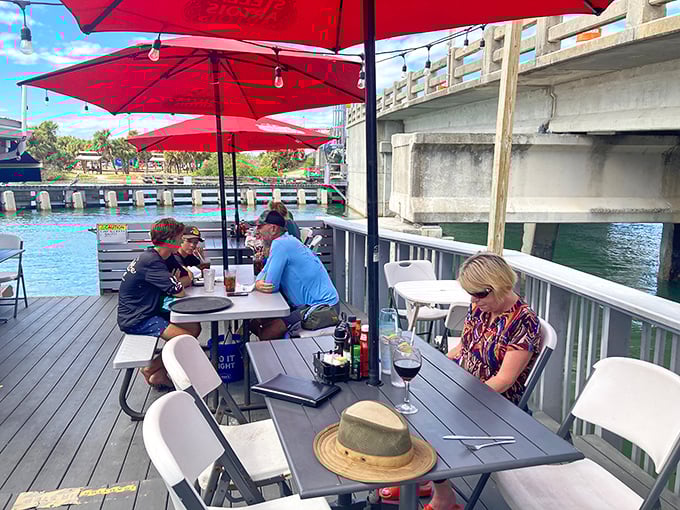 Waterfront dining with red umbrellas—where conversations flow as smoothly as the Intracoastal waters just a few feet away.