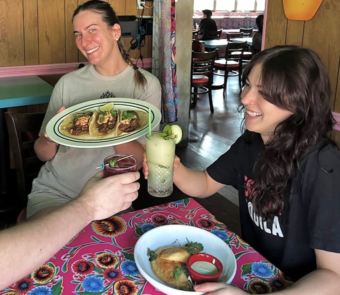 Friends sharing tacos and stories – the universal language of "you have to try this" needs no translation.