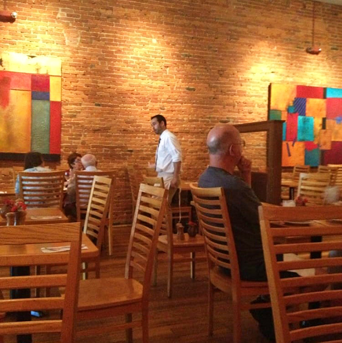 The dining room hums with the satisfied murmurs of people having religious experiences with pasta. Those colorful paintings aren't just decoration—they're conversation starters.
