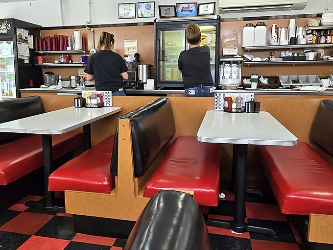 Red vinyl booths and checkerboard floors—the classic diner uniform that never goes out of style, where comfort trumps trendiness every single time.