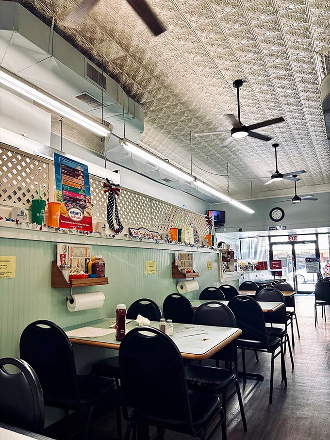 Classic American diner poetry – pressed tin ceiling, ceiling fans spinning stories, and tables waiting for your elbows and conversations.