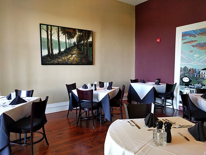 Elegant simplicity defines the dining room, where cream walls, burgundy accents, and polished wood floors set the stage for culinary drama.