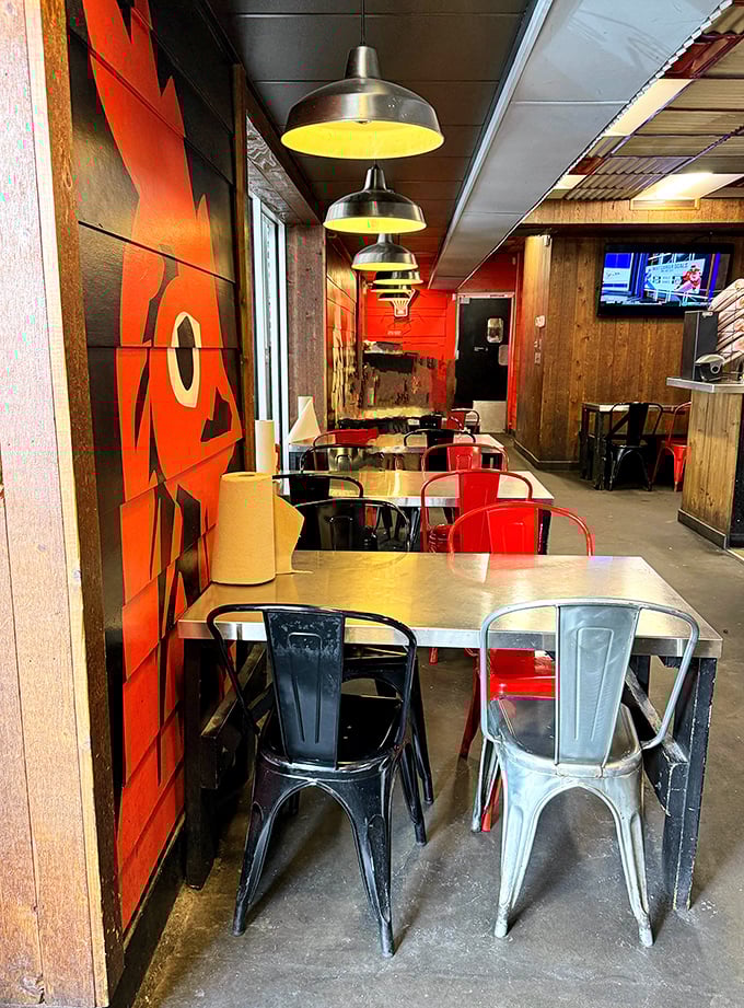 Red and black metal chairs against wooden tables create that perfect "come as you are" vibe where comfort food meets comfortable seating.