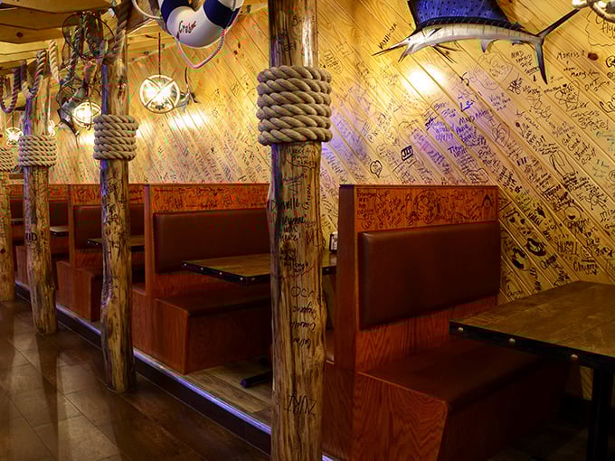 Wooden booths adorned with nautical rope and walls covered in visitors' signatures—each table a private dock for your seafood adventure.