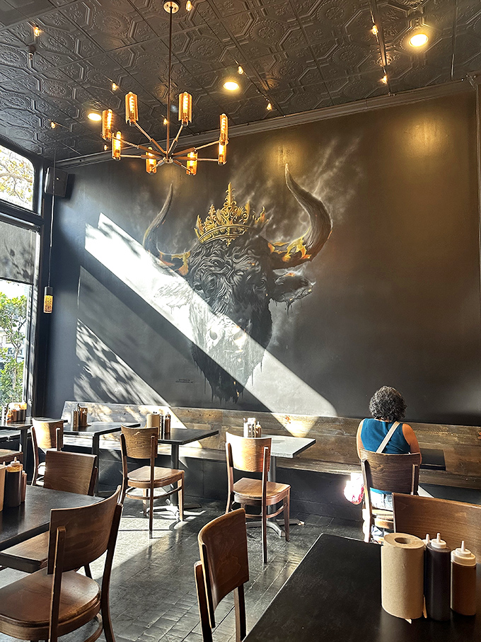 The crowned longhorn mural watches over diners like barbecue royalty, while sunlight streams in to highlight the temple of smoke you've entered.
